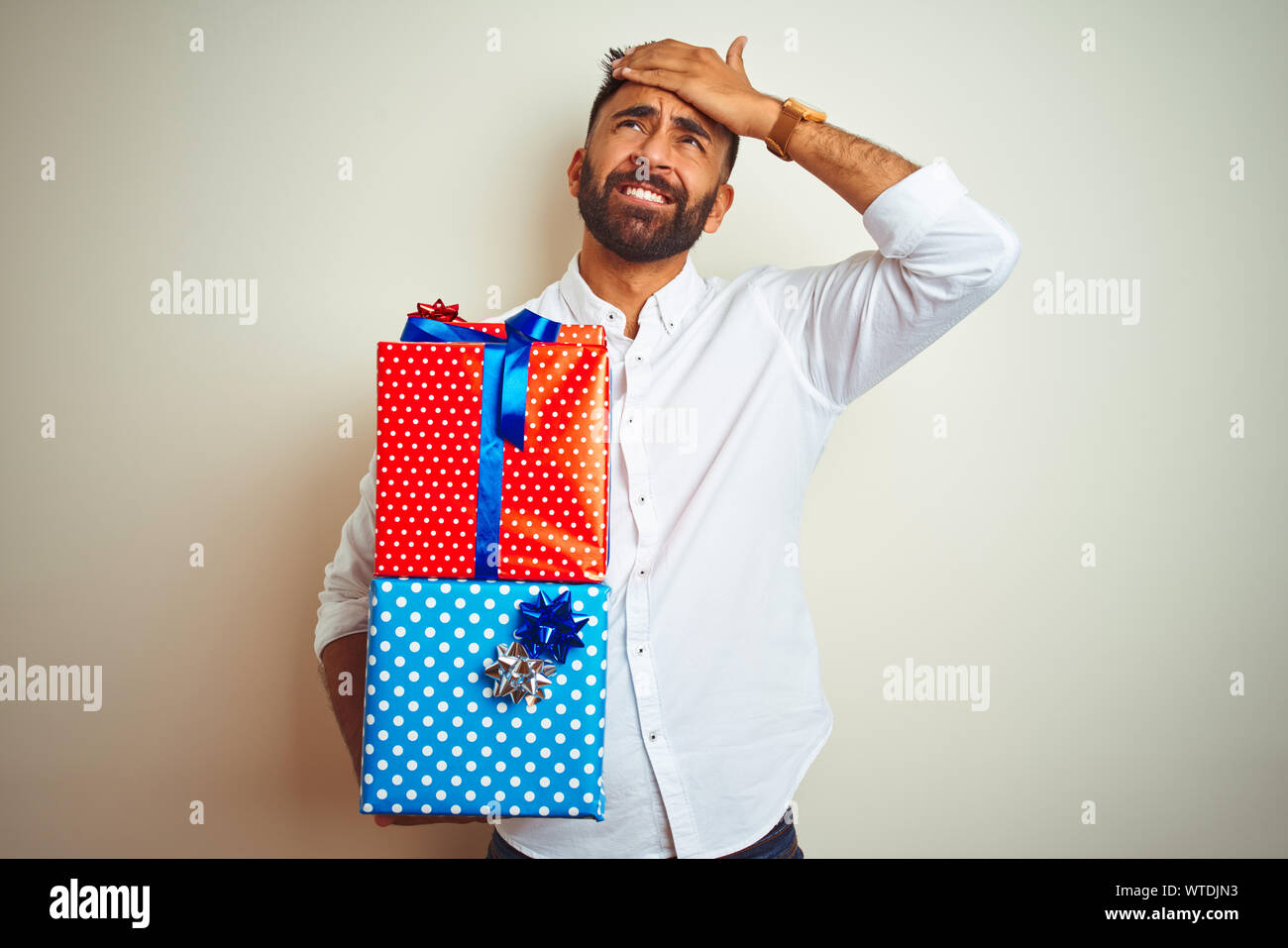 Young arab indian hispanic man holding birthday gifts standing over ...