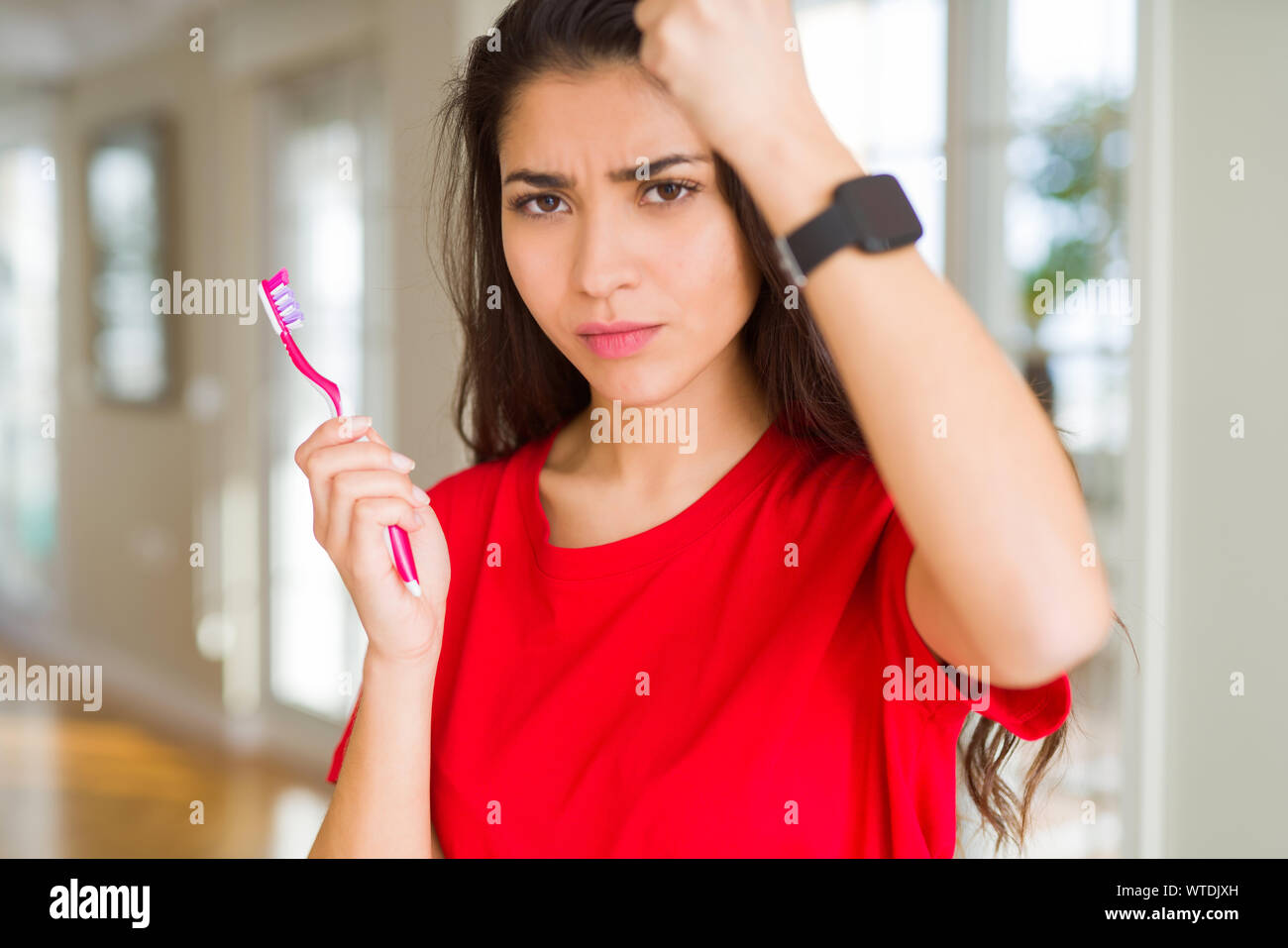 Young woman holding dental toothbrush annoyed and frustrated shouting ...