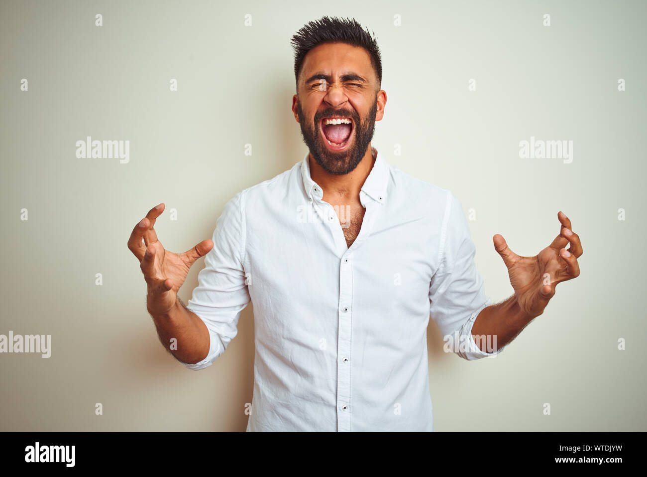 Young indian man wearing elegant shirt standing over isolated white ...