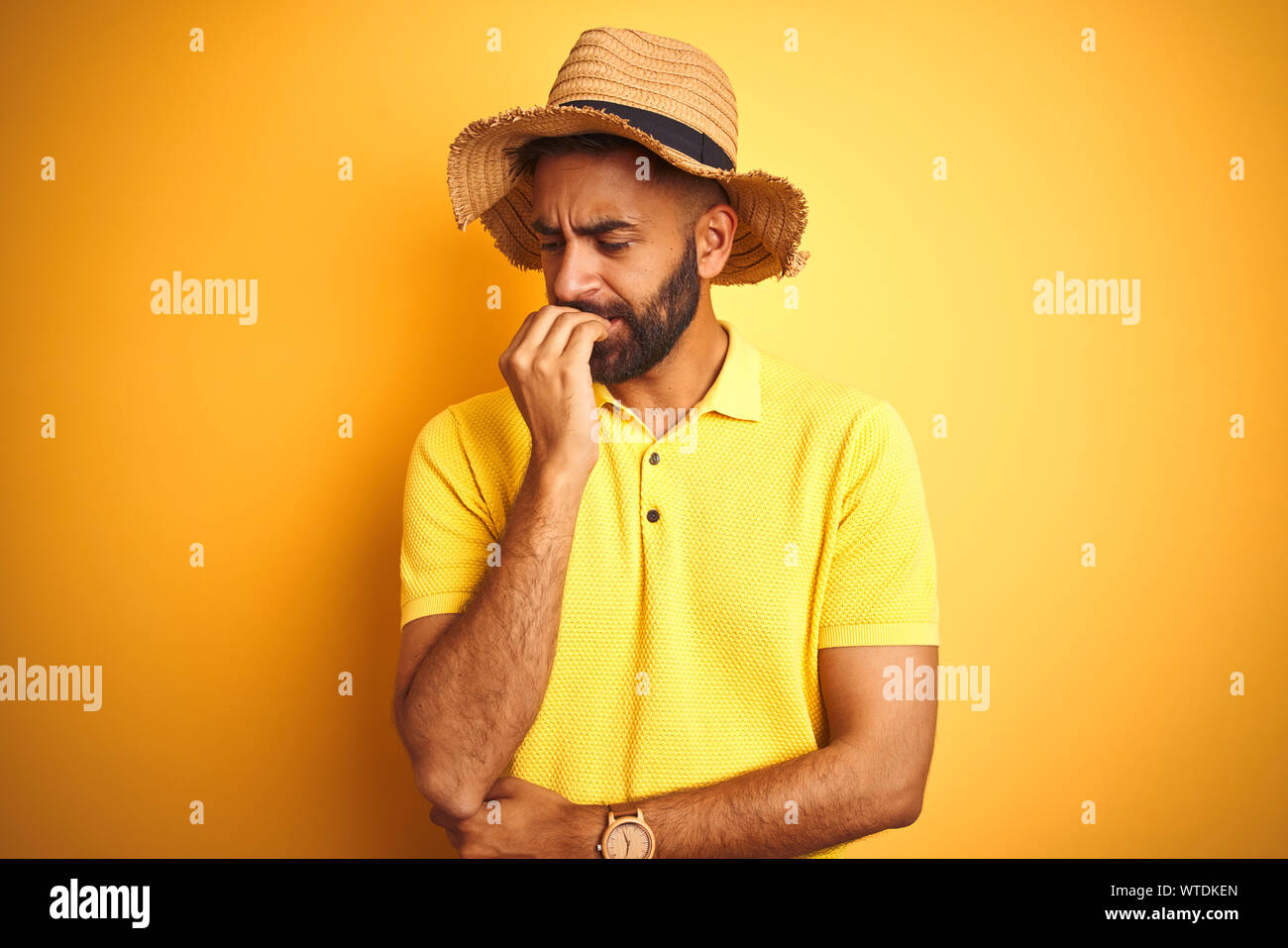 Young indian man on vacation wearing summer hat standing over isolated ...