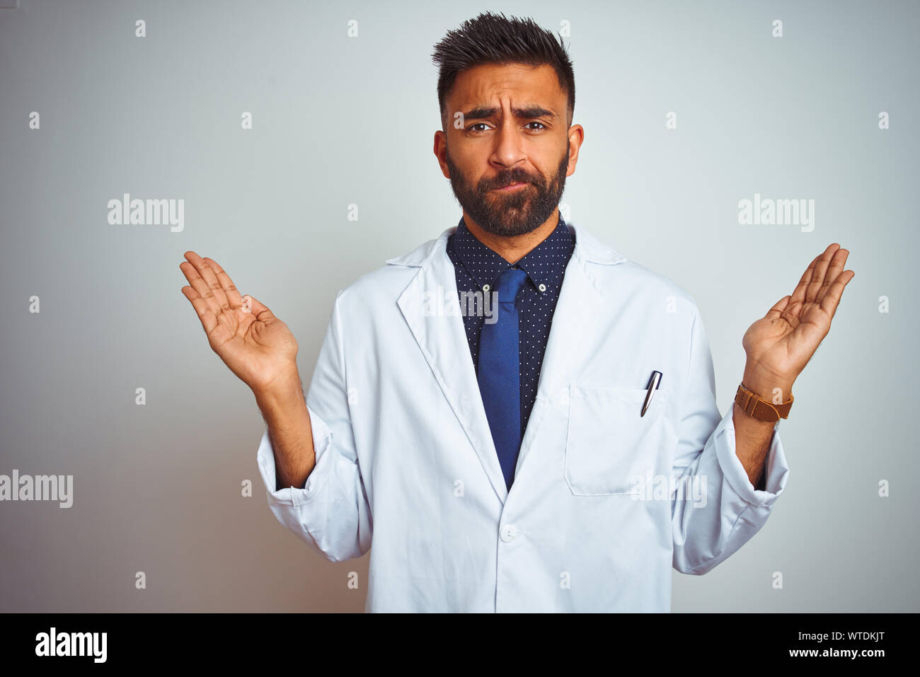 Young indian doctor man standing over isolated white background ...