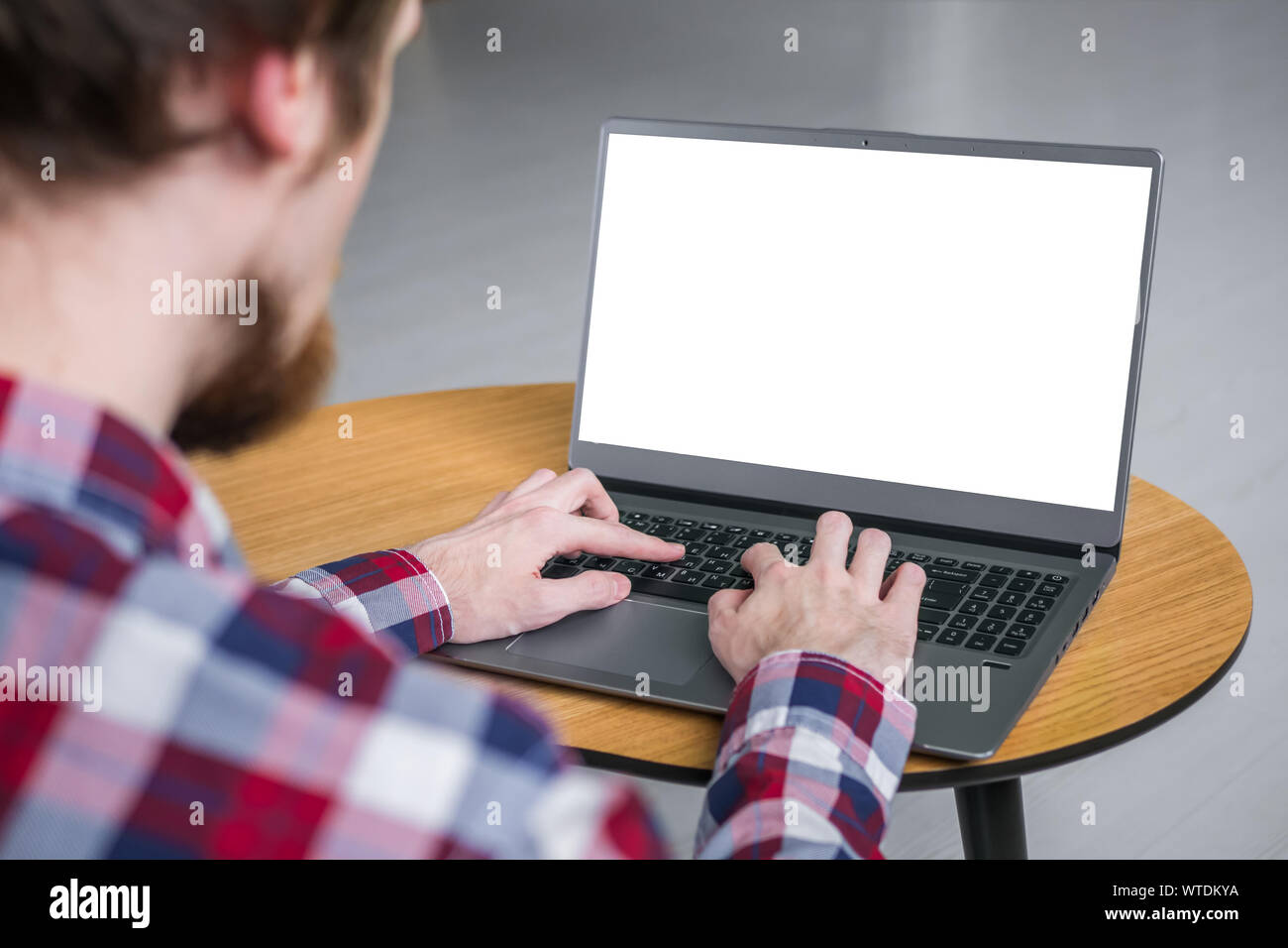 Man freelancer typing on laptop computer keyboard with white blank ...