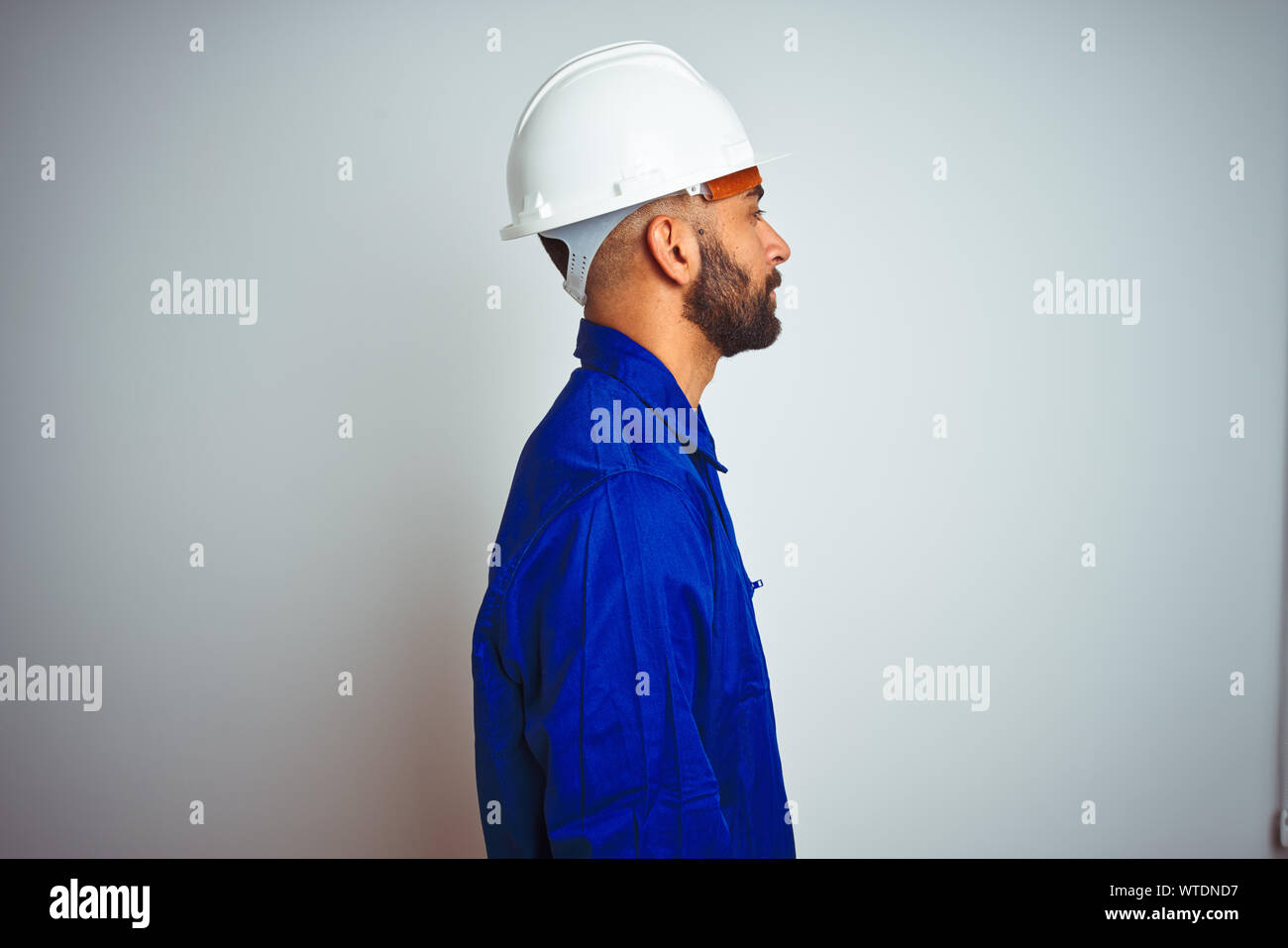 Handsome indian worker man wearing uniform and helmet over isolated ...