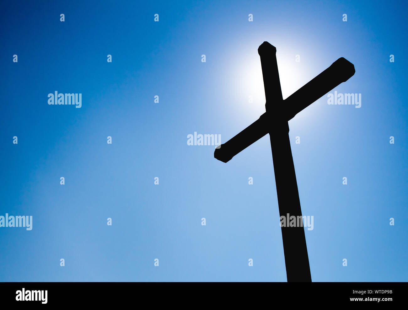 Silhouette photograph of a cross with sun flare on the side Stock Photo ...