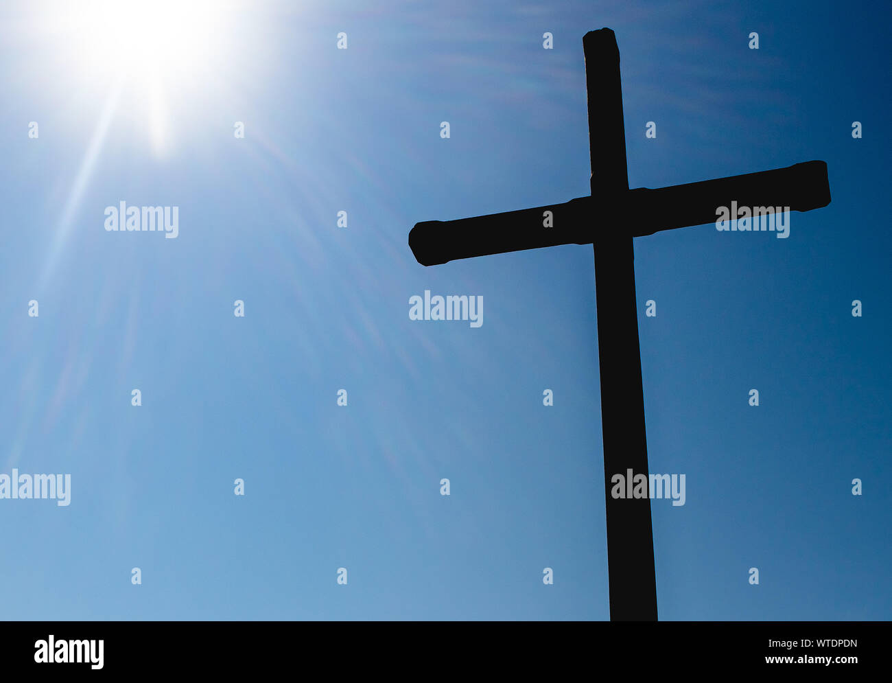 Silhouette photograph of a cross with sun flare on the side Stock Photo ...