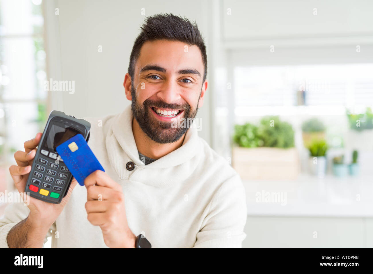 Business man smiling and holding point of sale terminal and credit card ...