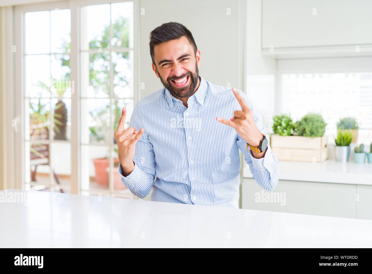 Handsome hispanic business man shouting with crazy expression doing ...