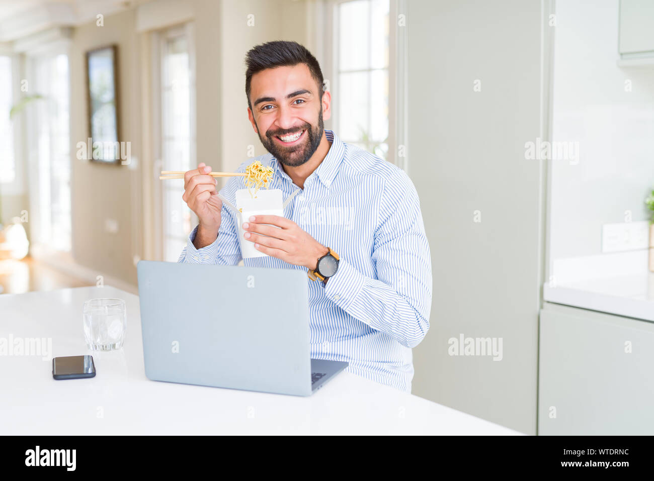 Business man eating asian food from delivery while working using ...