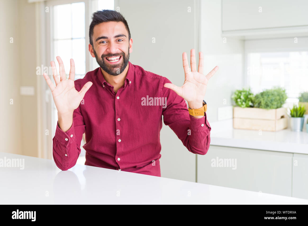Handsome hispanic business man showing and pointing up with fingers ...