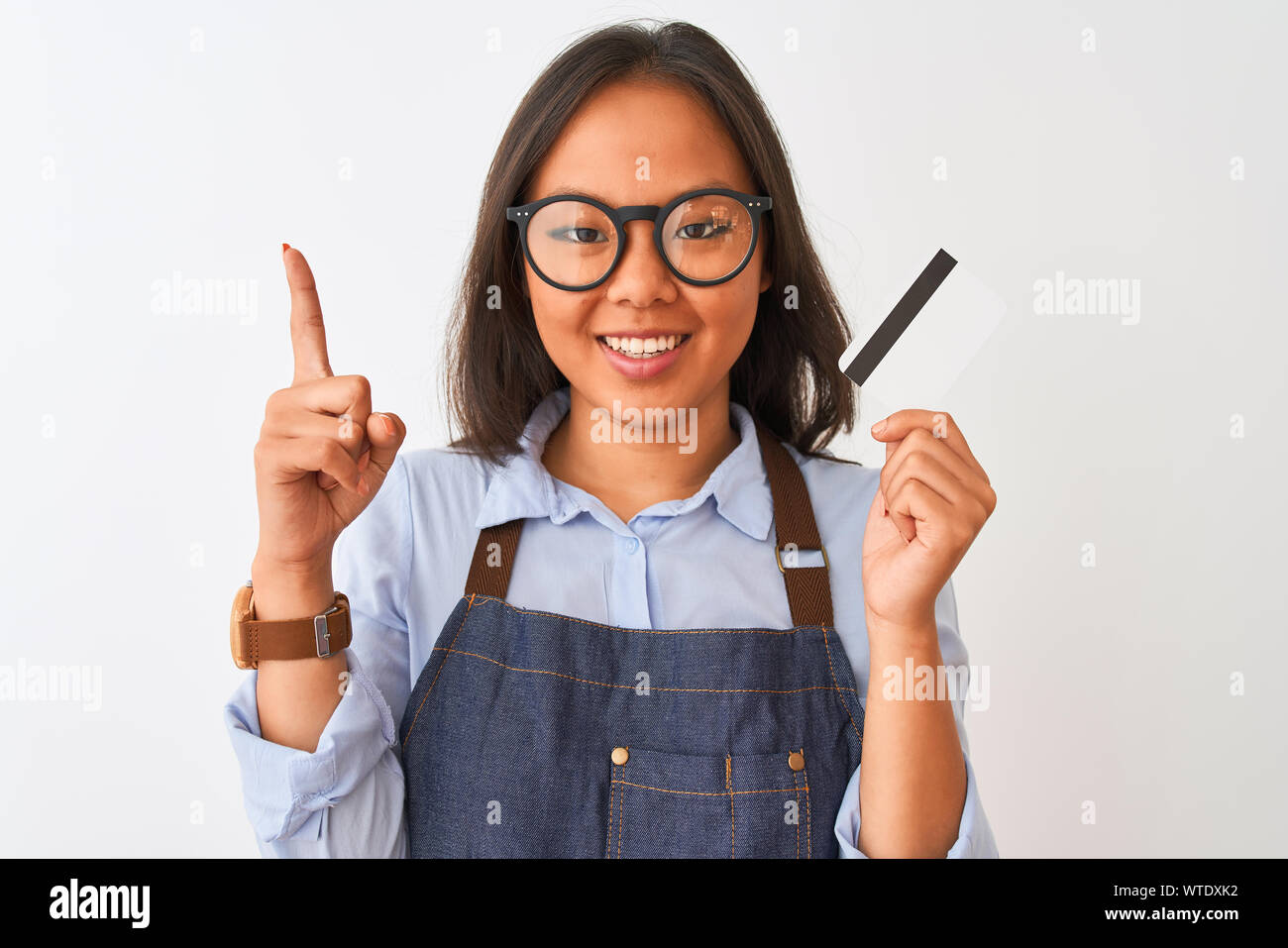 Chinese shopkeeper woman wearing glasses holding credit card over ...