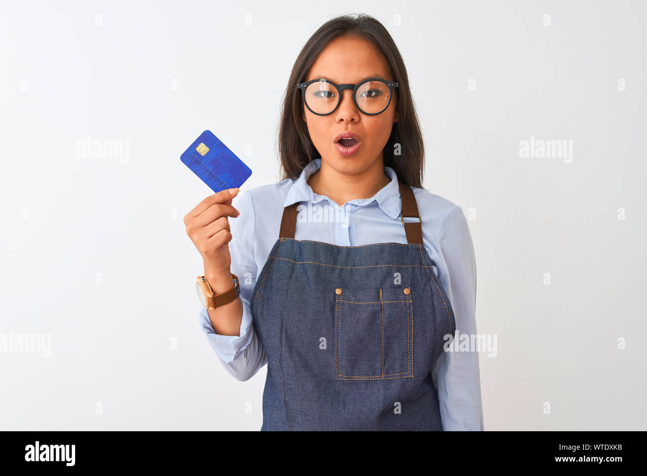 Chinese shopkeeper woman wearing glasses holding credit card over ...