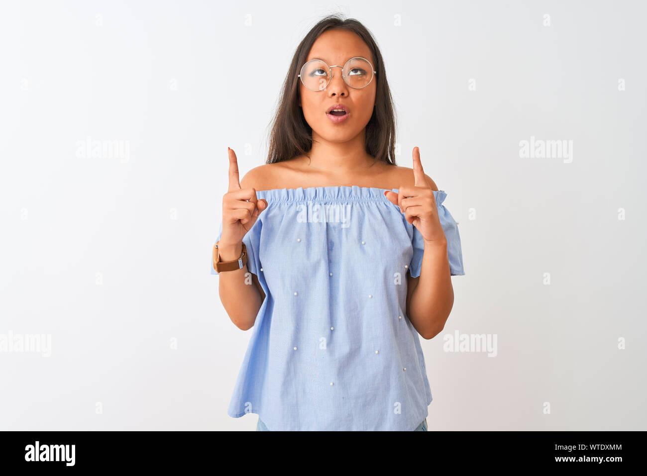 Young chinese woman wearing blue t-shirt and glasses over isolated ...