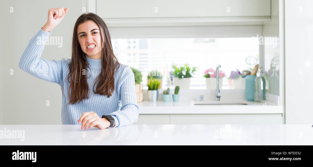 Wide angle picture of beautiful young woman sitting on white table at ...