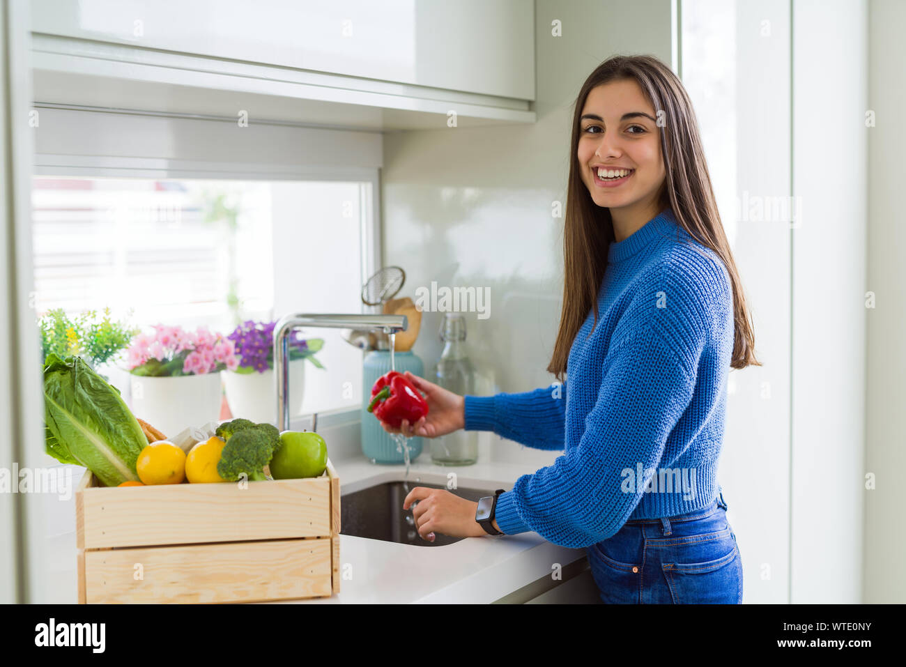 Young woman washing vegetables and fruit using water from sink Stock ...