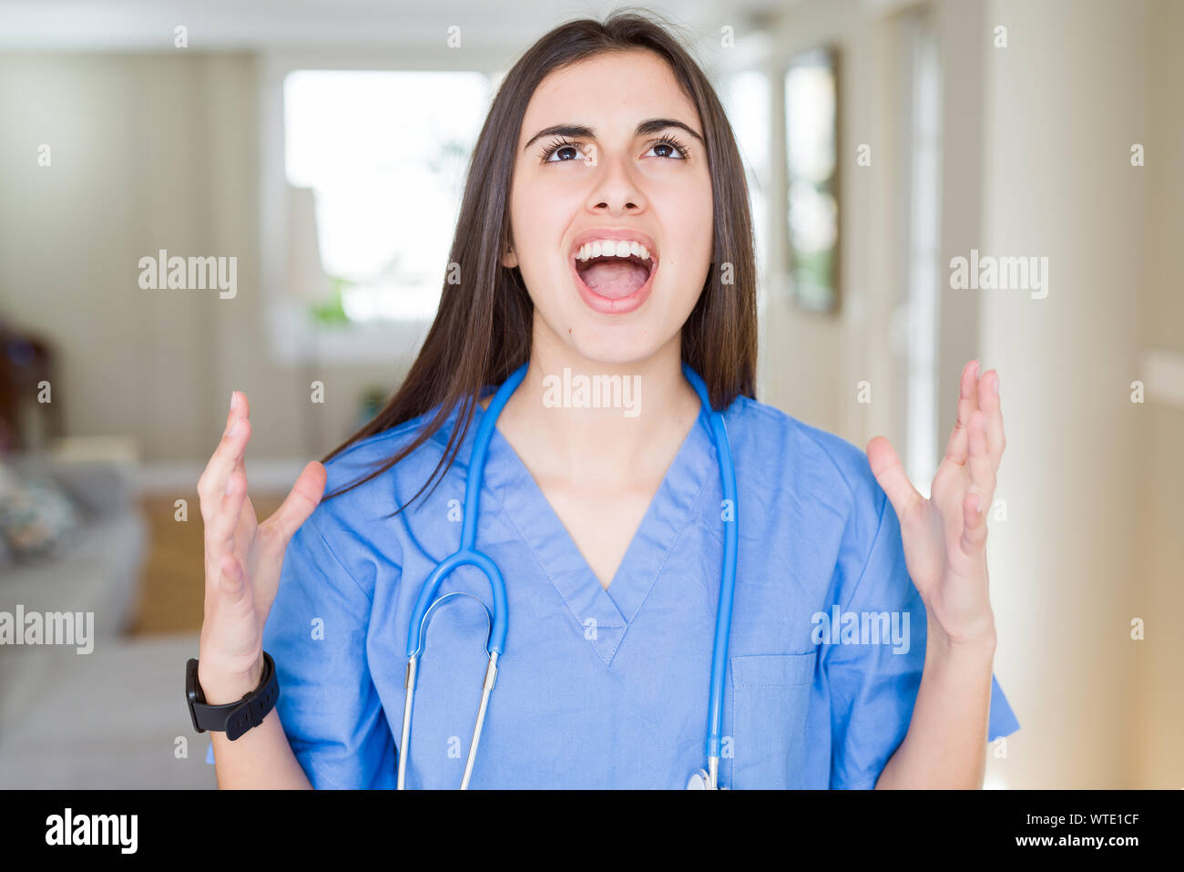 Beautiful young nurse woman wearing uniform and stethoscope at the ...