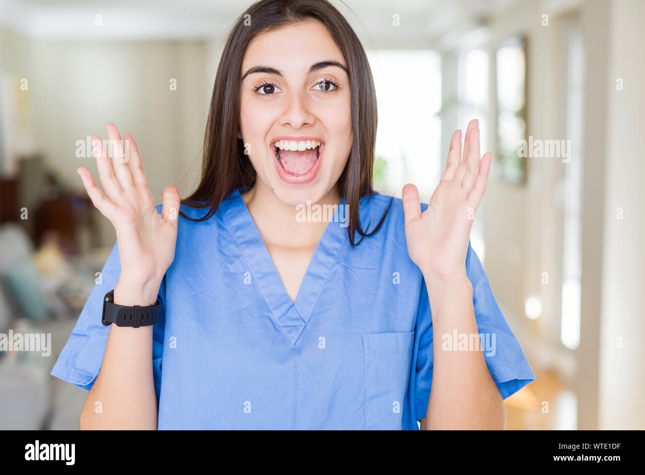 Beautiful young nurse woman at the clinic celebrating crazy and amazed ...