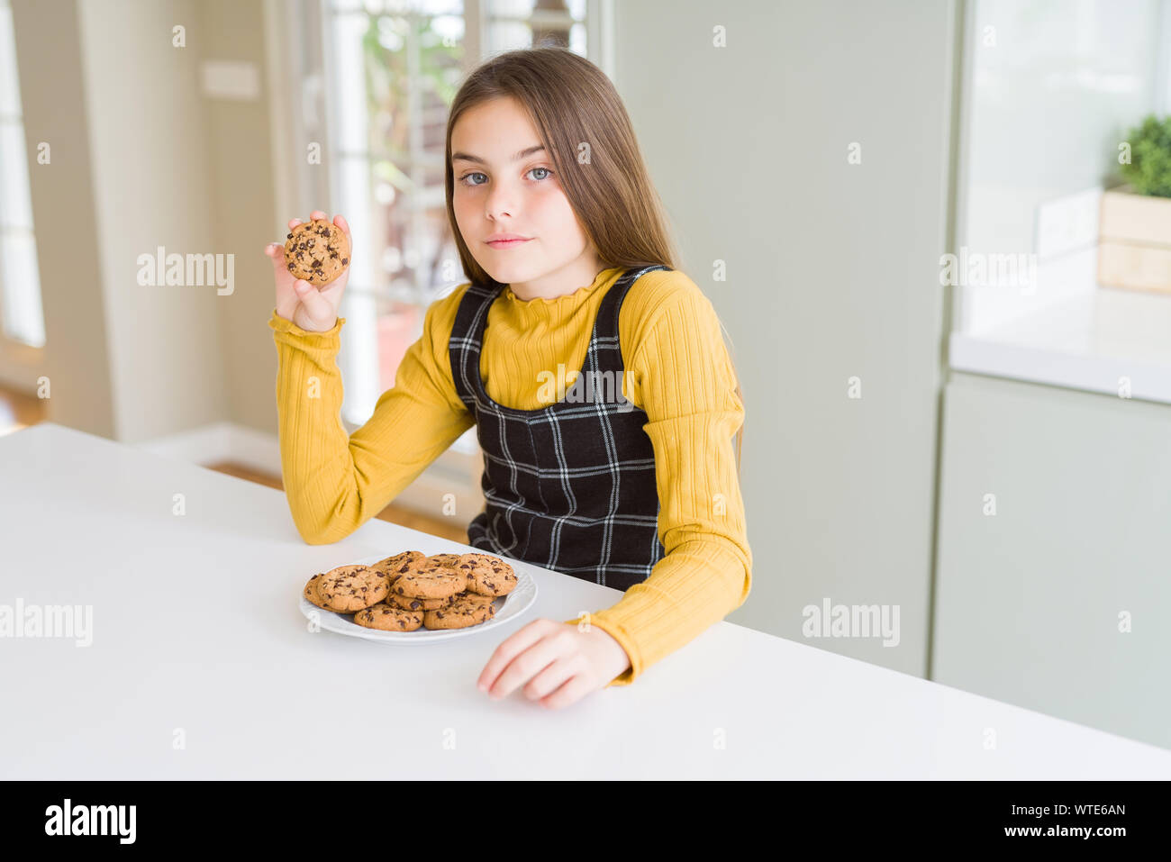 Beautiful young girl kid eating chocolate chips cookies with a ...