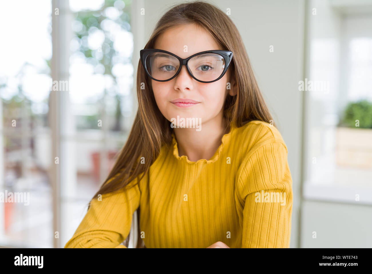 Beautiful young girl kid wearing glasses Relaxed with serious ...