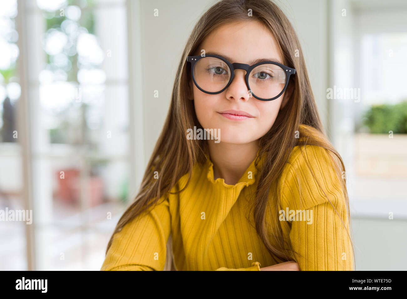 Beautiful young girl kid wearing glasses Relaxed with serious ...