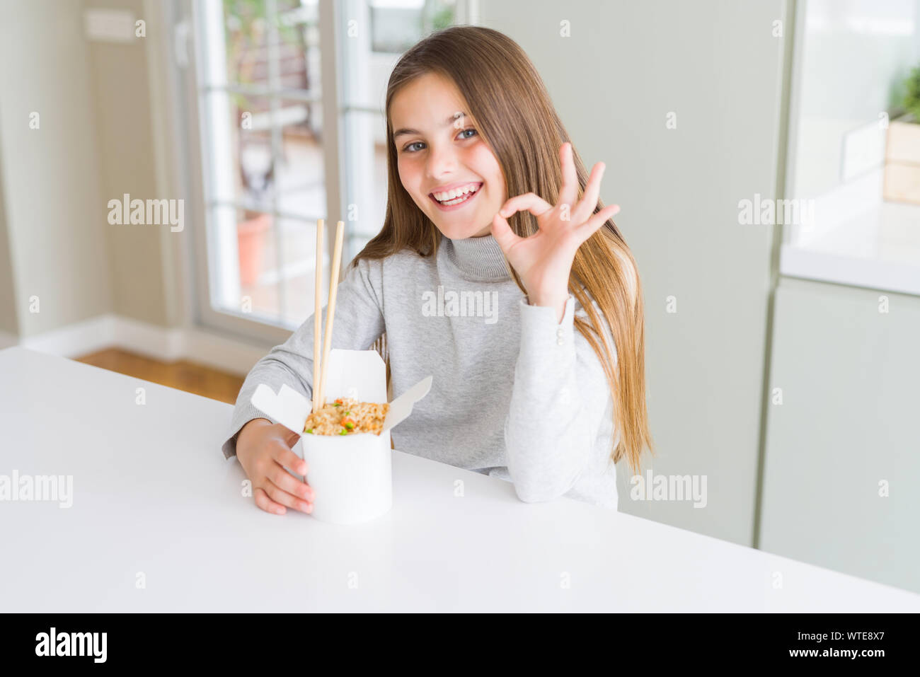 Beautiful young girl kid eating asian rice in delivery box doing ok ...