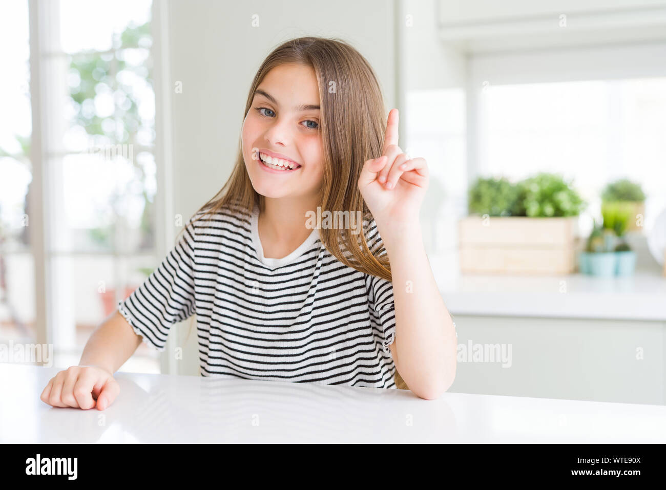 Beautiful young girl kid wearing stripes t-shirt showing and pointing ...