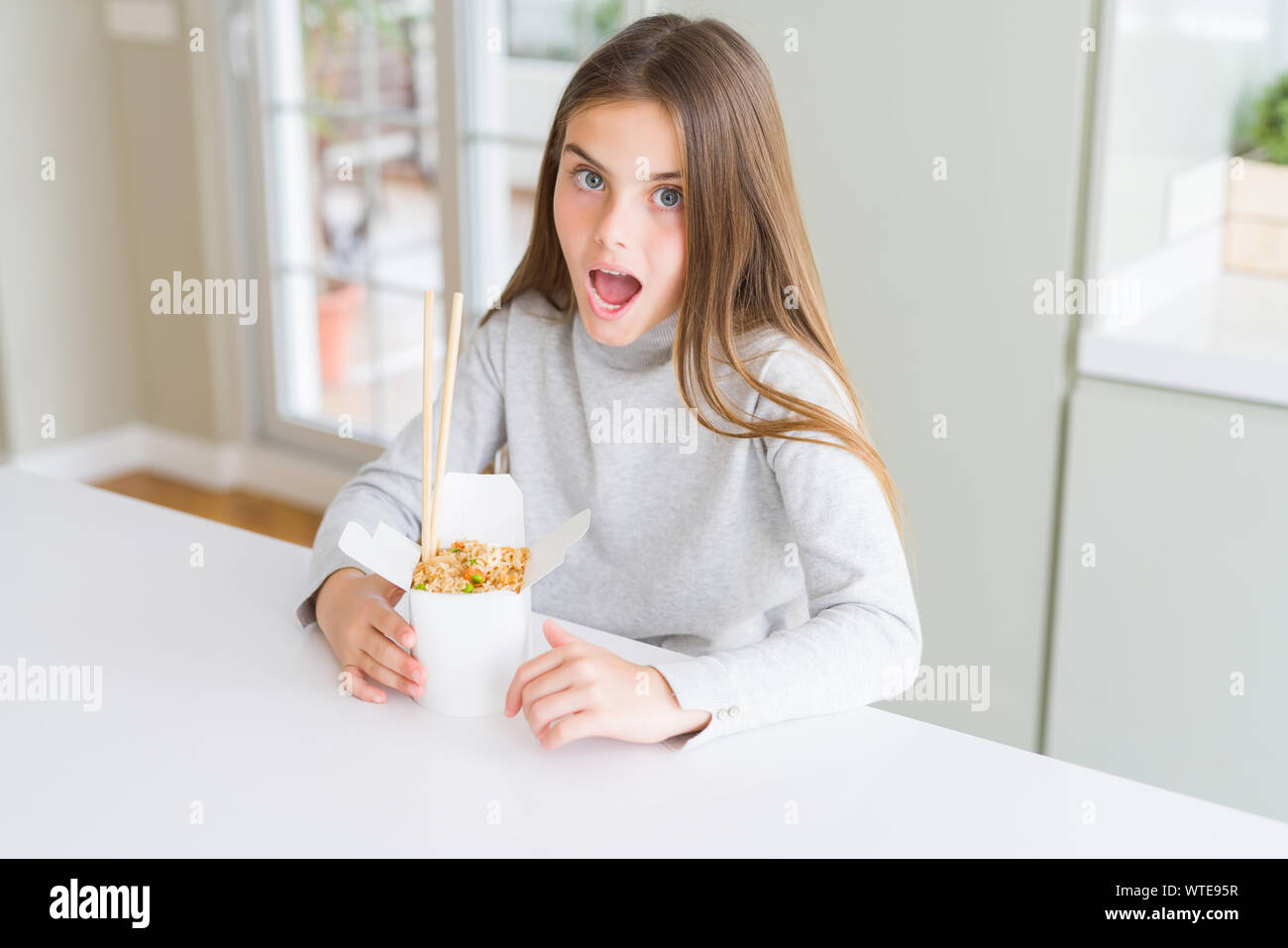 Beautiful young girl kid eating asian rice in delivery box scared in ...