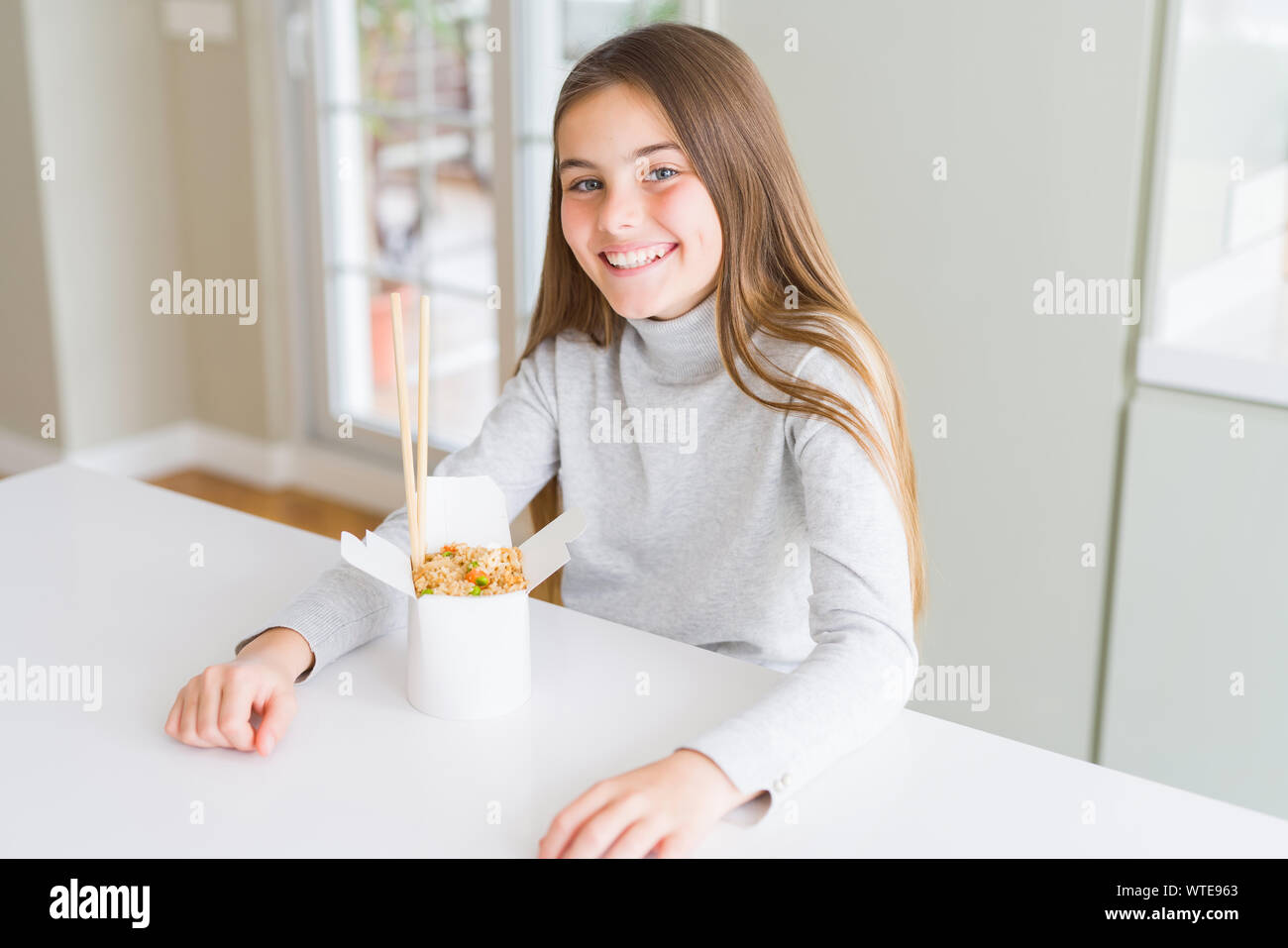 Beautiful young girl kid eating asian rice in delivery box with a happy ...