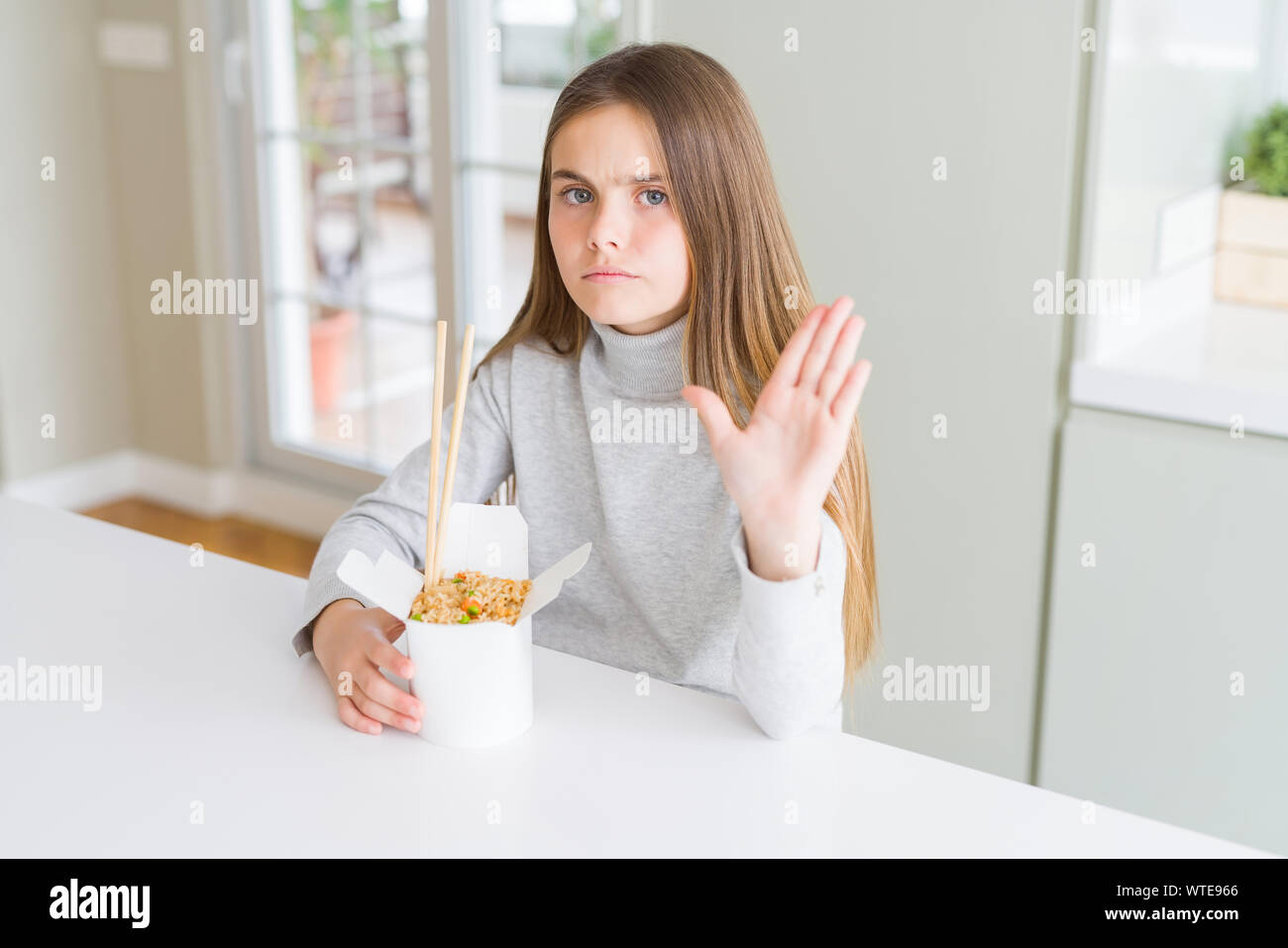 Beautiful young girl kid eating asian rice in delivery box with open ...