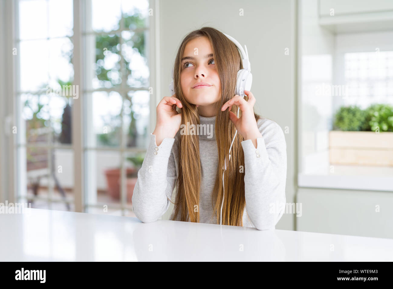 Beautiful young girl wearing headphones listening to music and dancing ...
