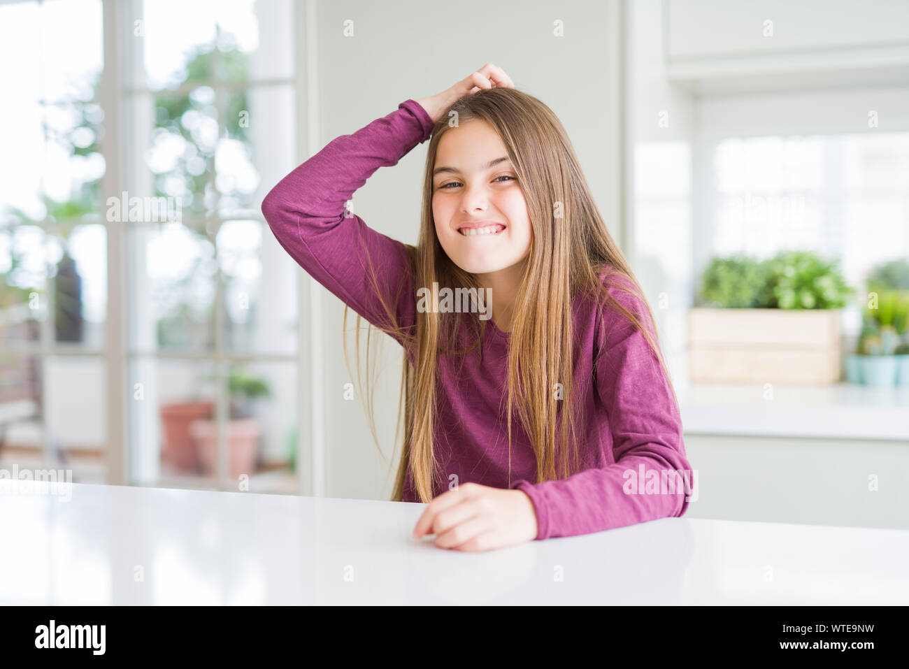 Beautiful young girl kid on white table confuse and wonder about ...