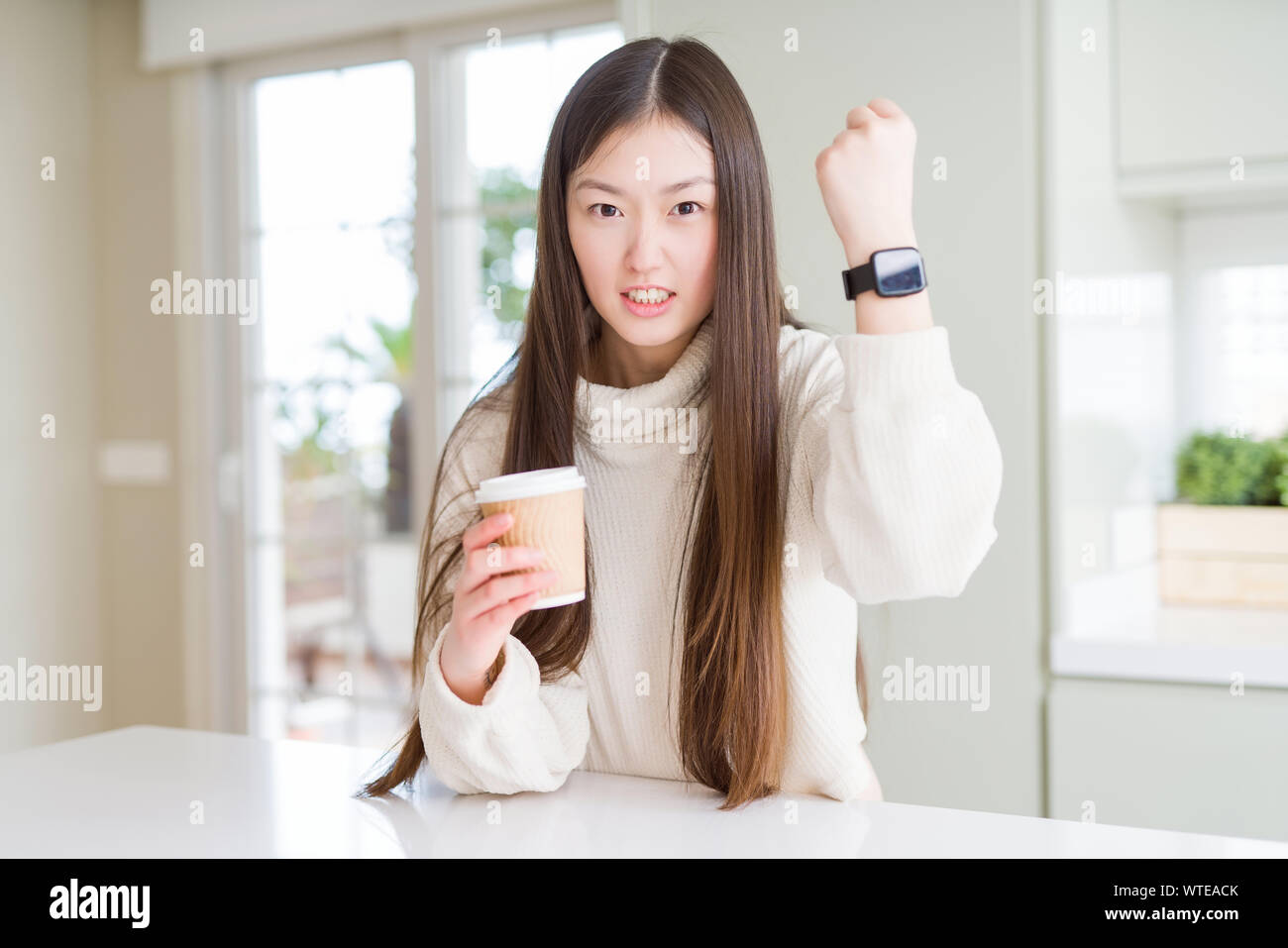 Beautiful Asian woman drinking a coffee in a take away paper cup ...