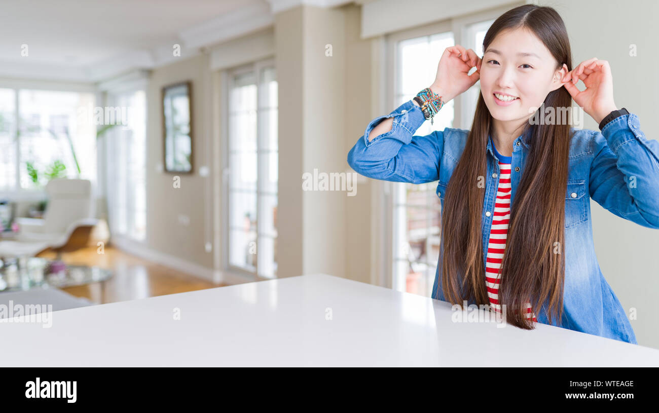 Young beautiful asian woman with long hair wearing denim jacket Smiling ...