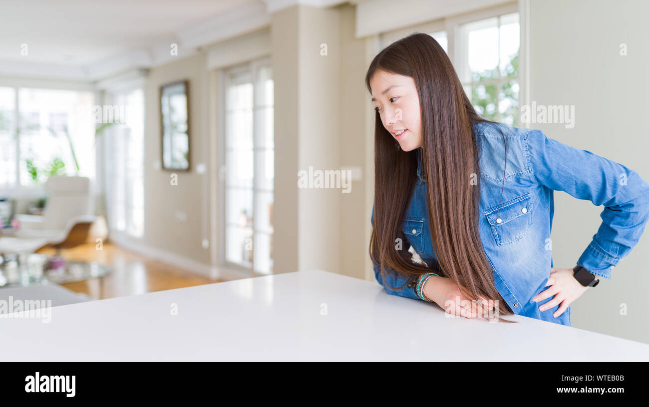 Young beautiful asian woman with long hair wearing denim jacket ...