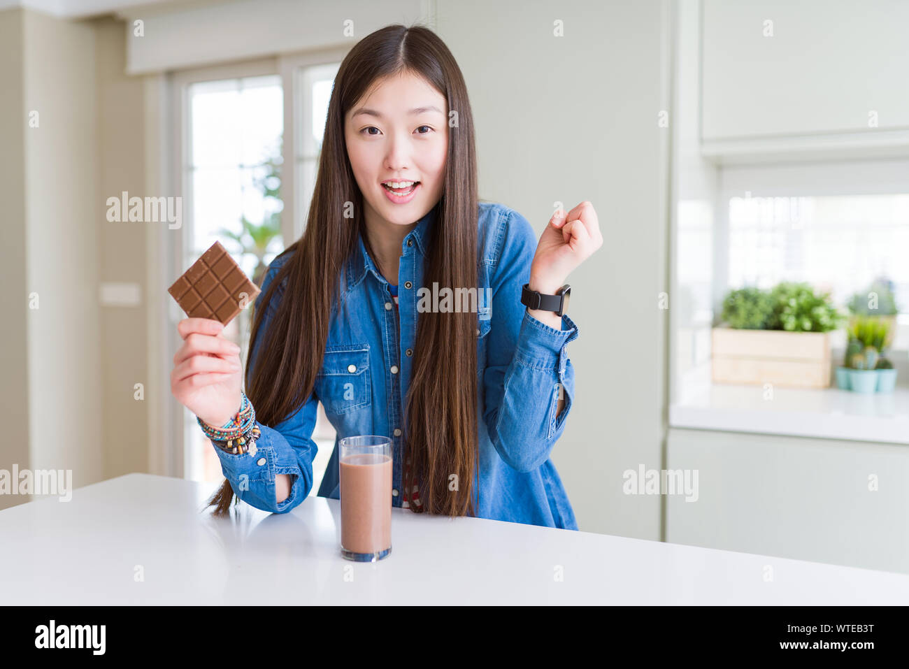 Beautiful Asian woman drinking chocolate milkshake and holding ...