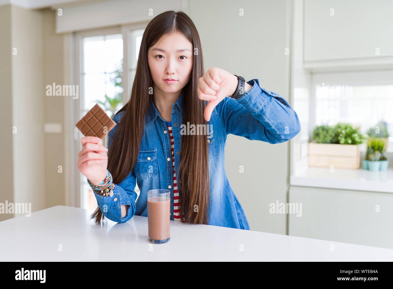 Beautiful Asian woman drinking chocolate milkshake and holding ...