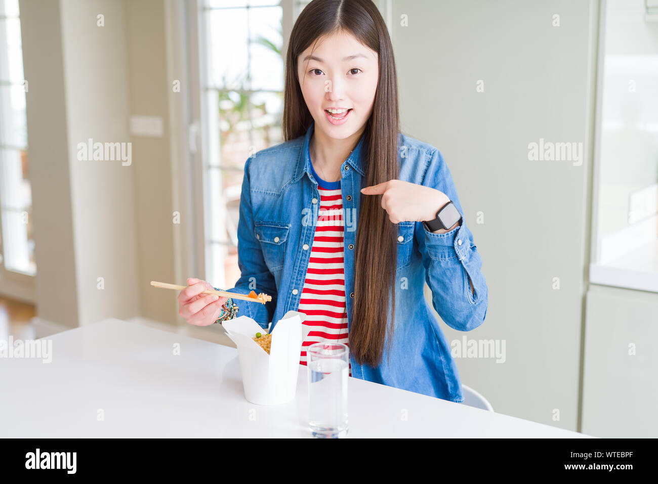 Beautiful Asian woman eating asian rice in delivery box with surprise ...