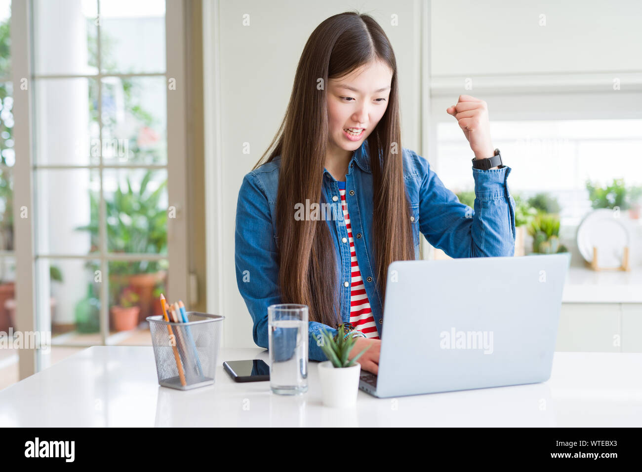 Beautiful Asian woman working using computer laptop annoyed and ...