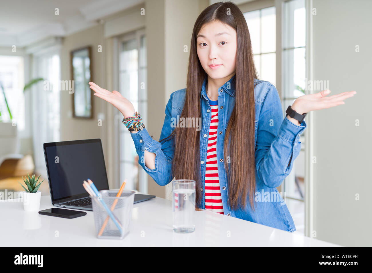 Beautiful Asian woman working using computer laptop clueless and ...