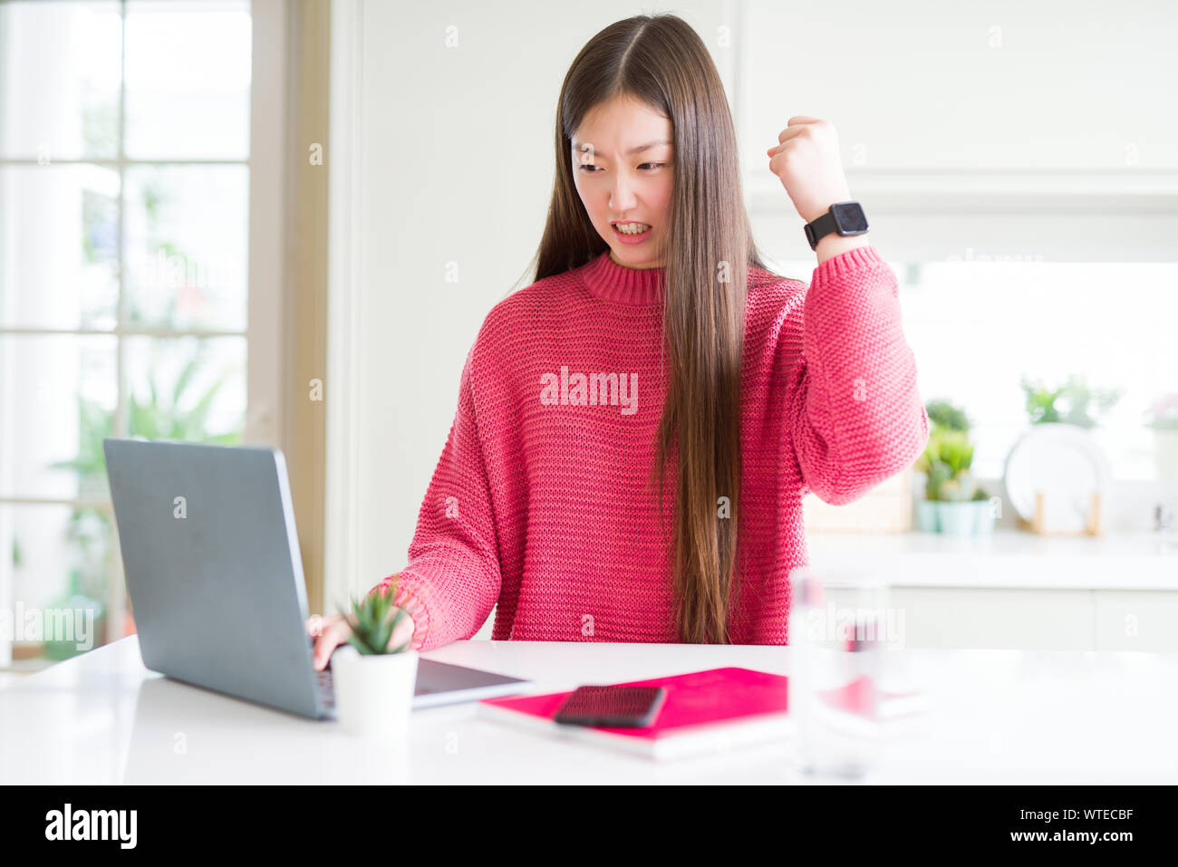 Beautiful Asian woman working using computer laptop annoyed and ...