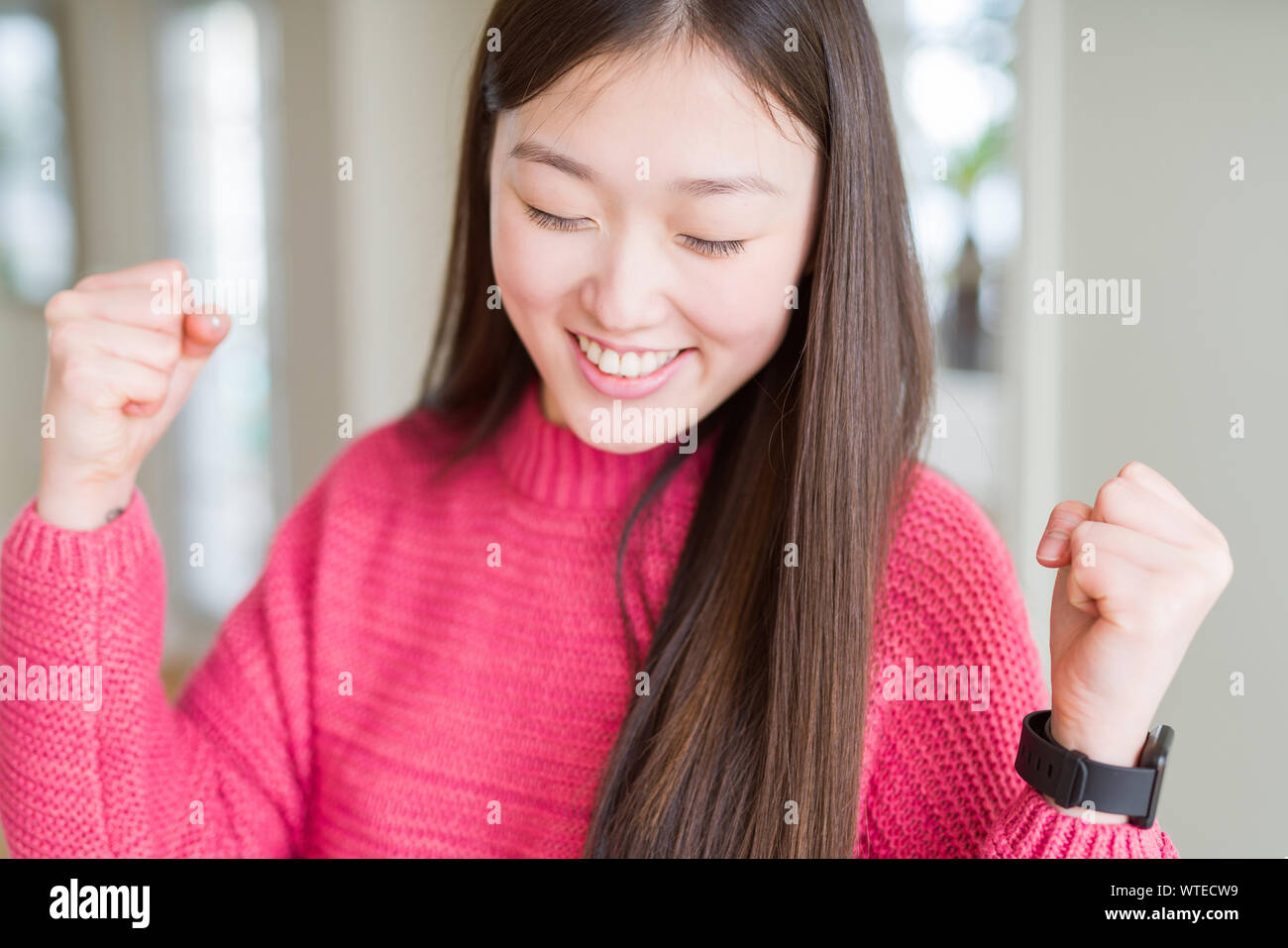 Beautiful Asian Woman Wearing Pink Sweater Excited For Success With