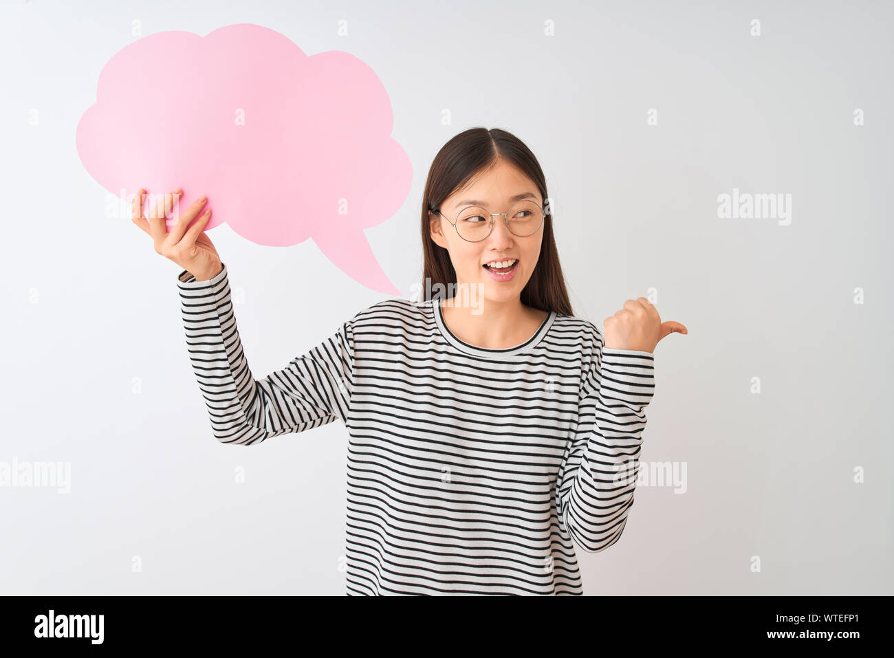 Young chinese woman holding cloud speech bubble over isolated white ...