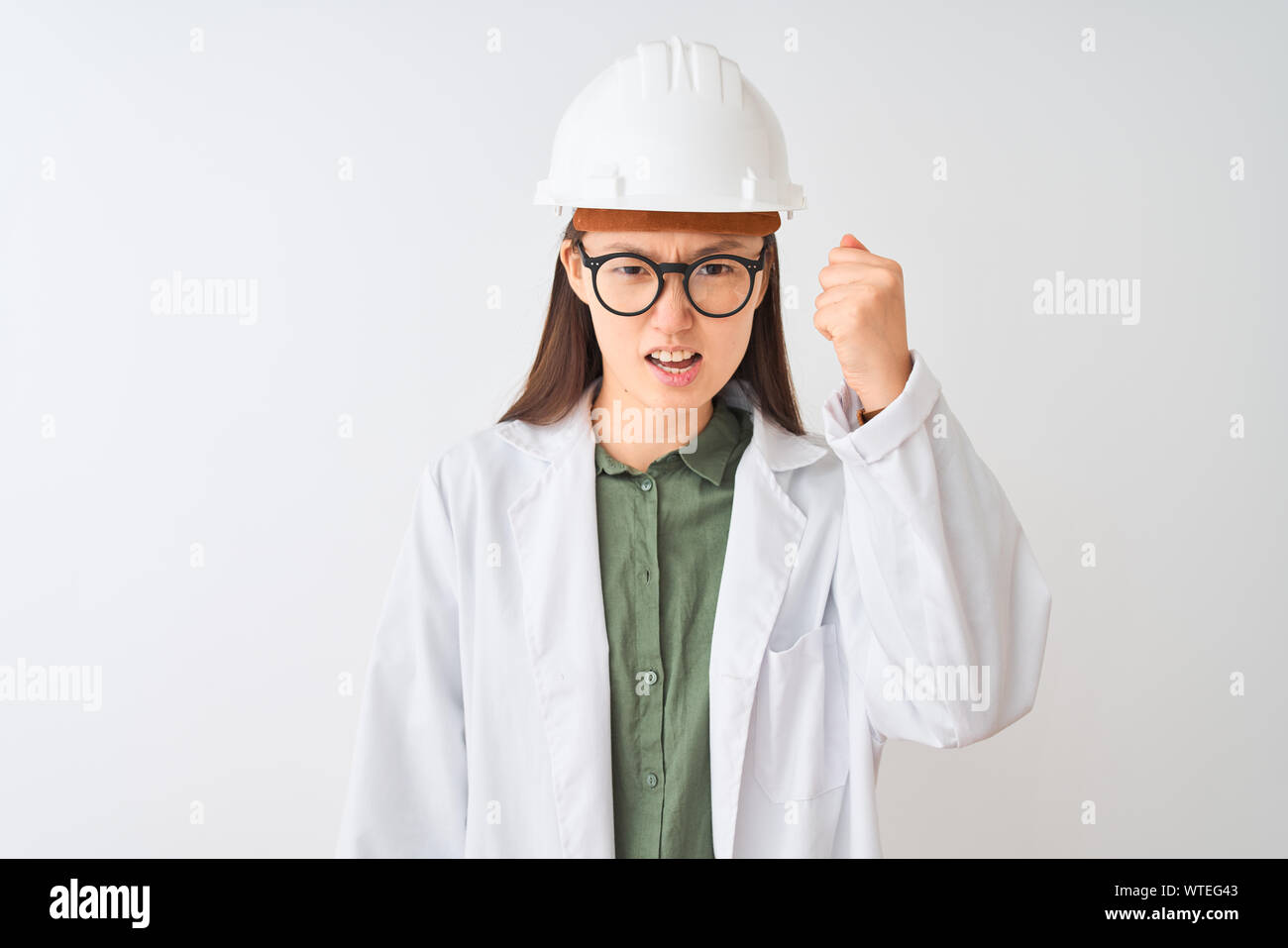 Young chinese engineer woman wearing coat helmet glasses over isolated ...