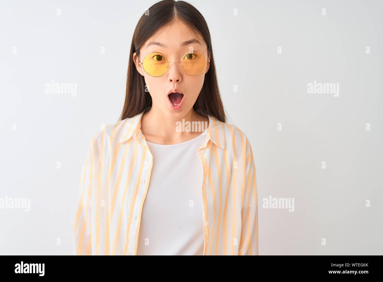 Young chinese woman wearing striped shirt and glasses over isolated ...