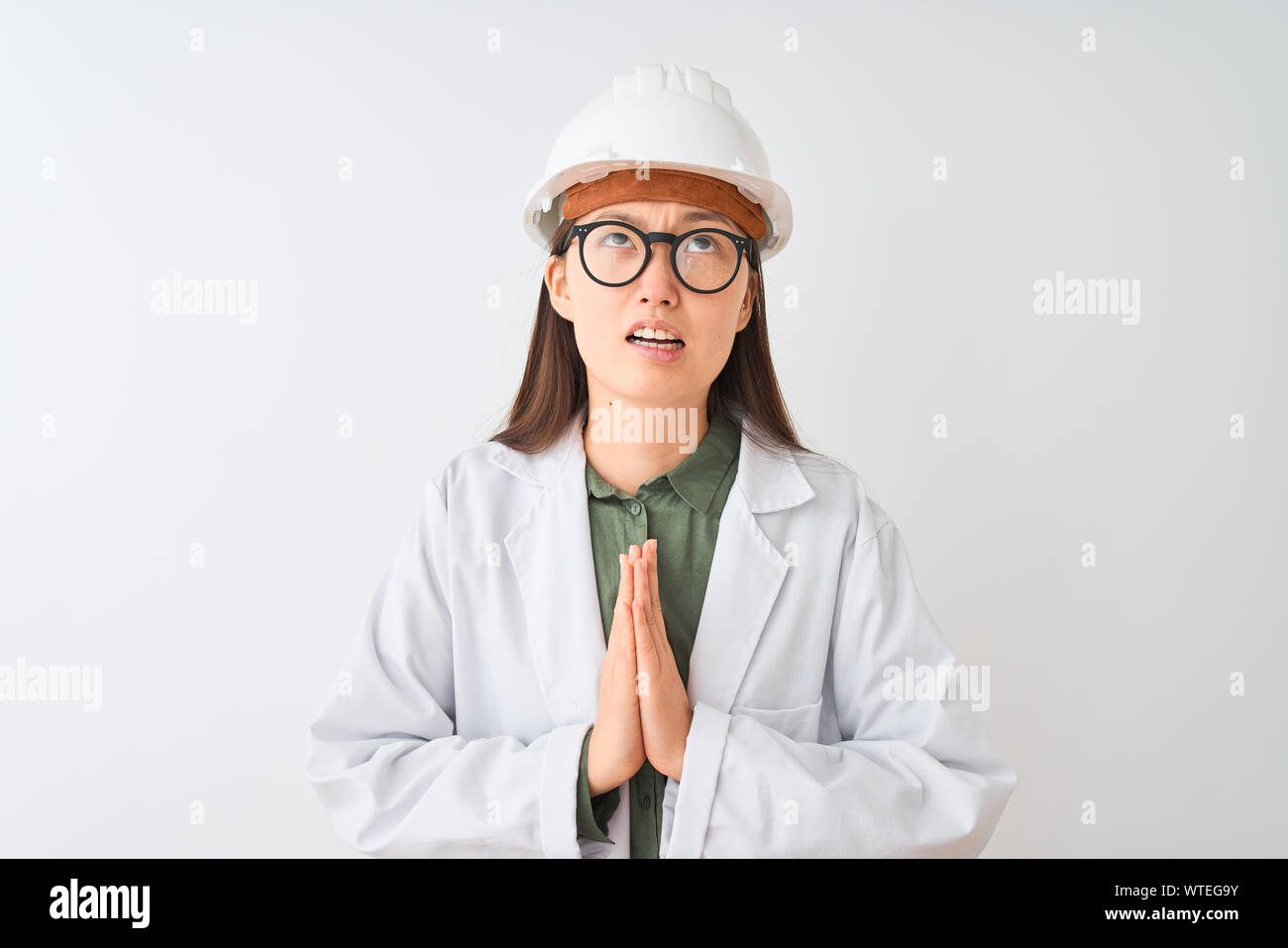 Young chinese engineer woman wearing coat helmet glasses over isolated ...