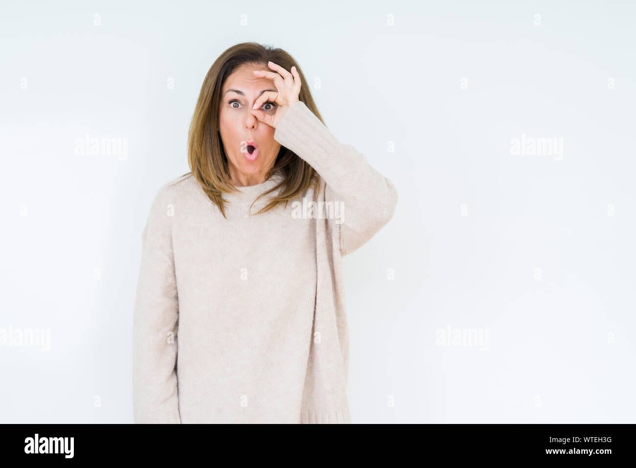 Beautiful middle age woman over isolated background doing ok gesture ...
