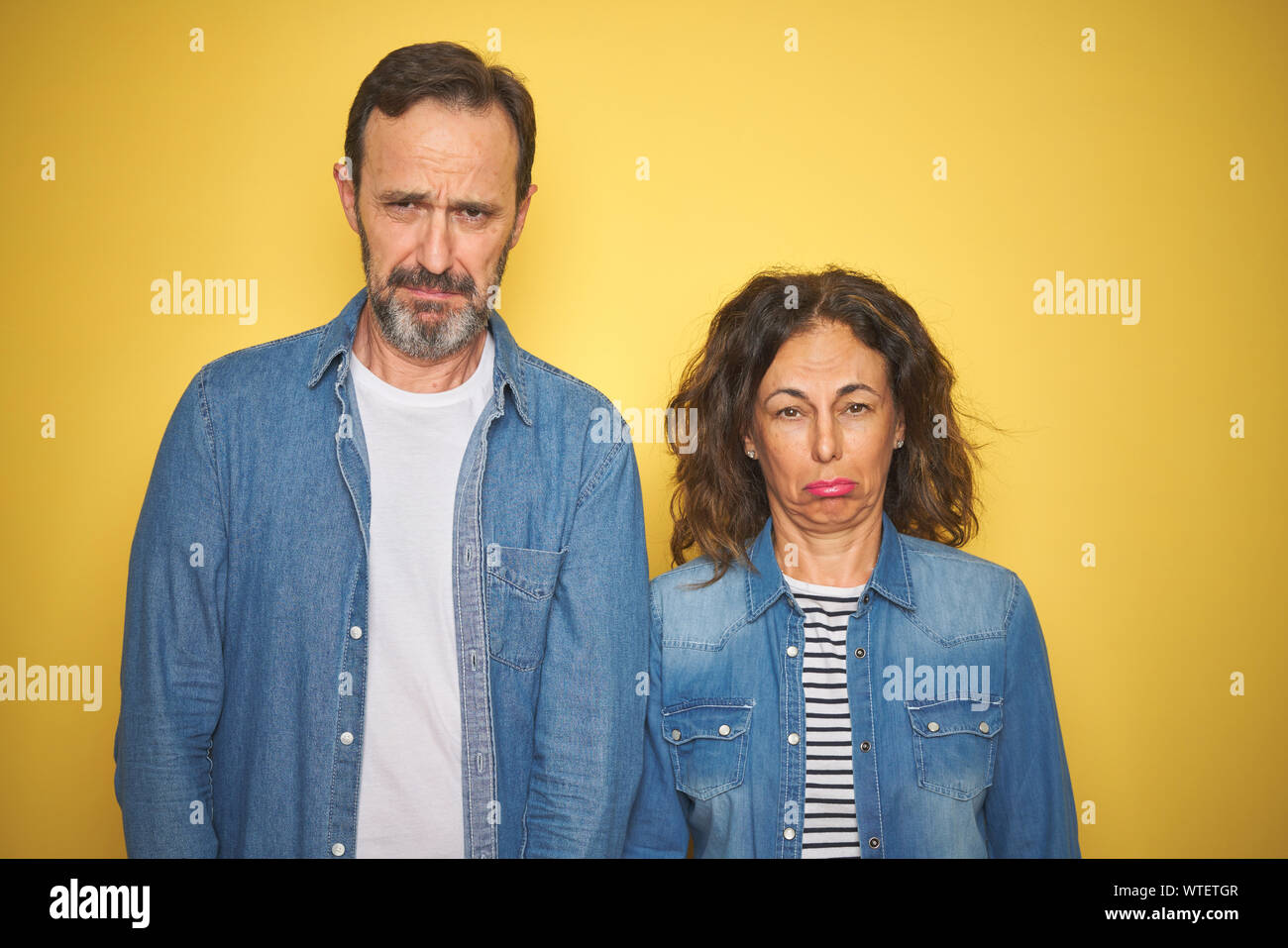 Beautiful middle age couple together wearing denim shirt over isolated ...