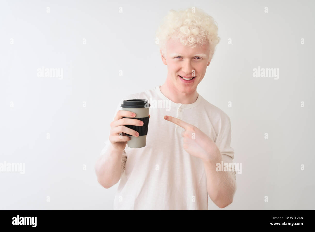 Young albino blond man drinking coffee standing over isolated white ...