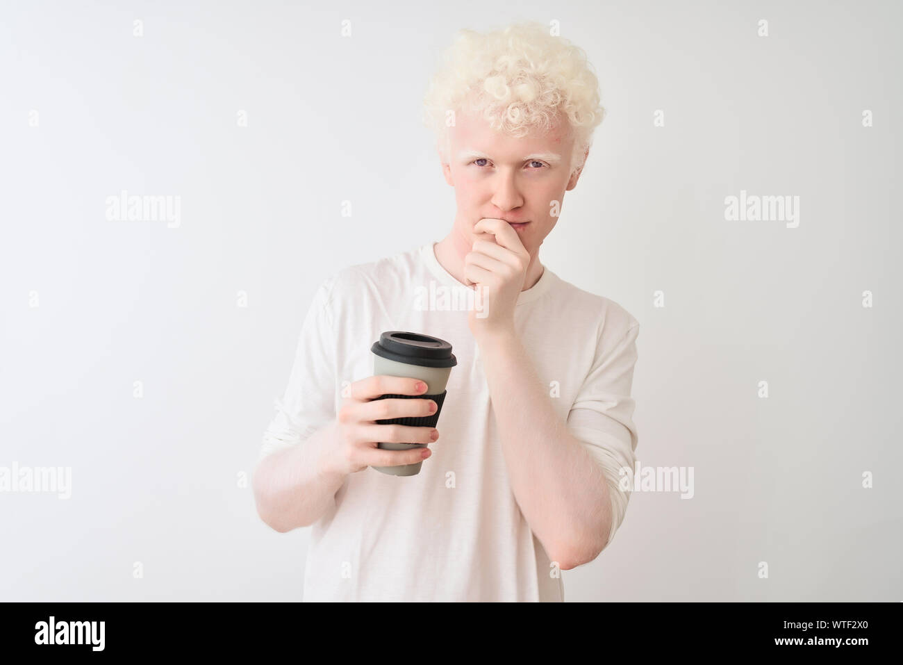 Young albino blond man drinking coffee standing over isolated white ...