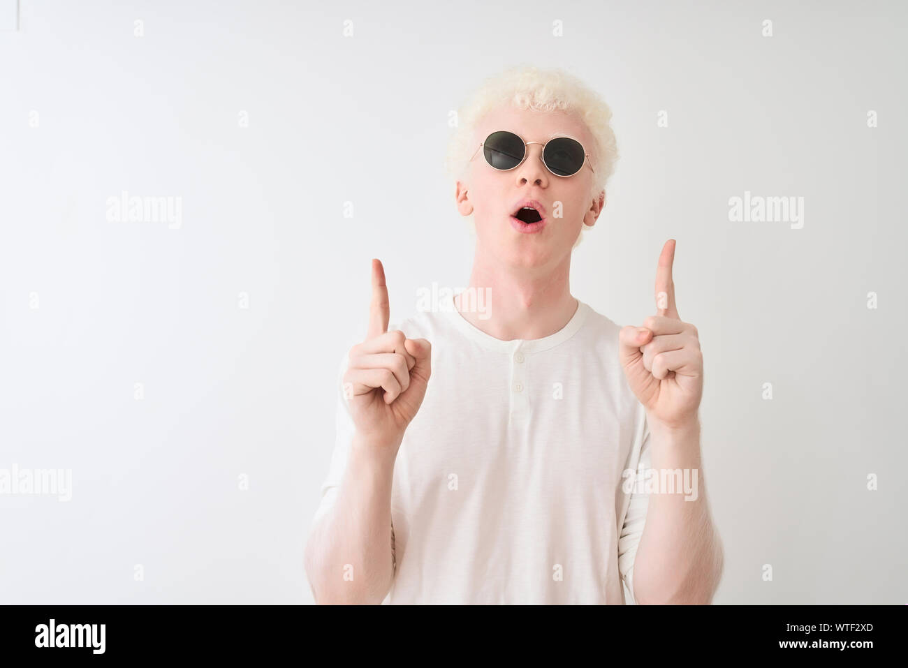 Young albino blond man wearing t-shirt and sunglasses over isolated ...
