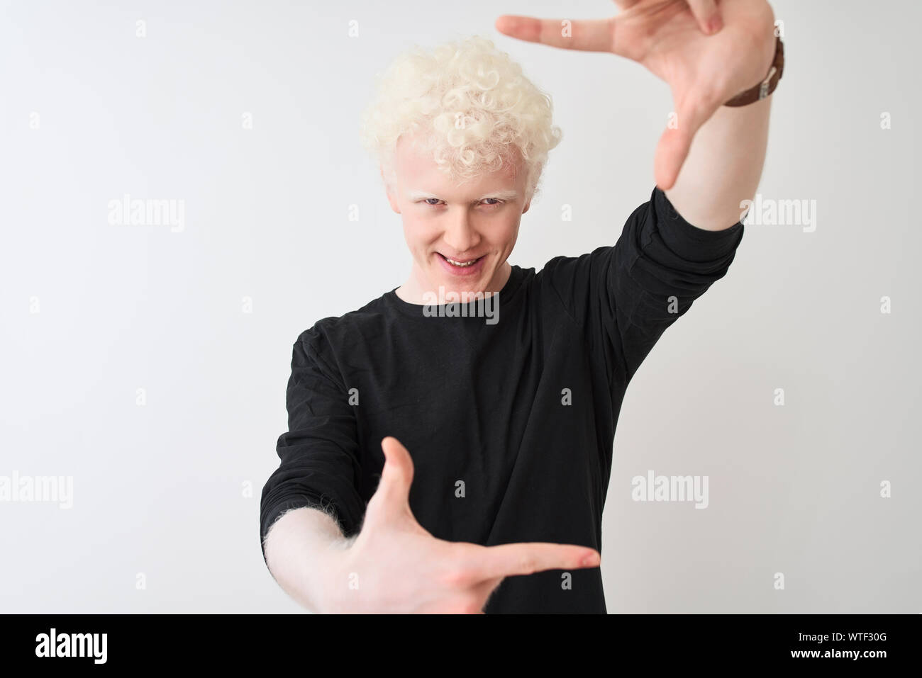 Young albino blond man wearing black t-shirt standing over isolated ...